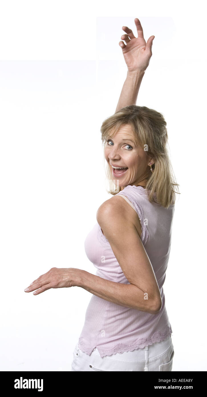 A portrait of a happy woman in her 40's wearing a pink top smiling and ...