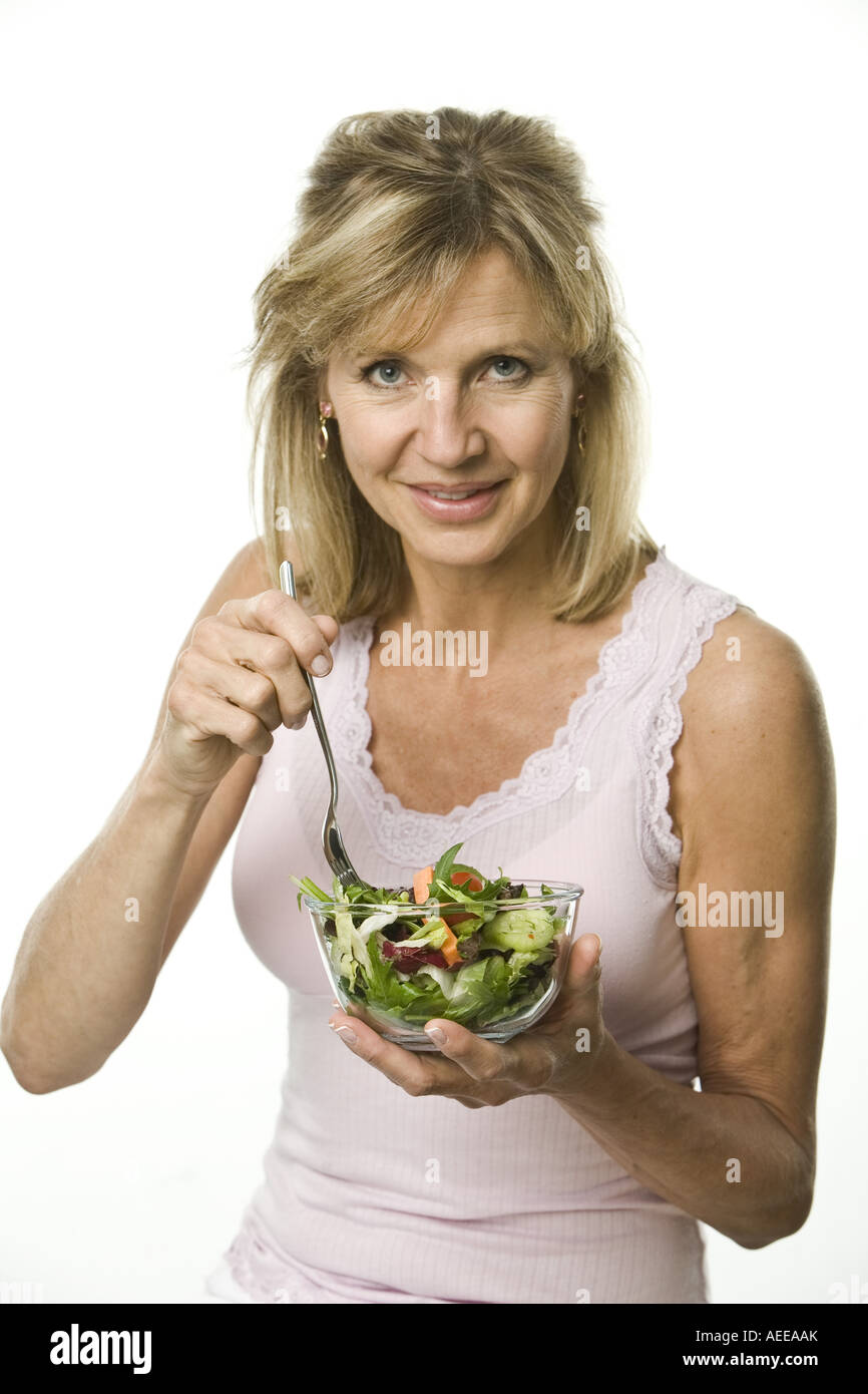 A slender woman in her forties eating a salad Stock Photo - Alamy