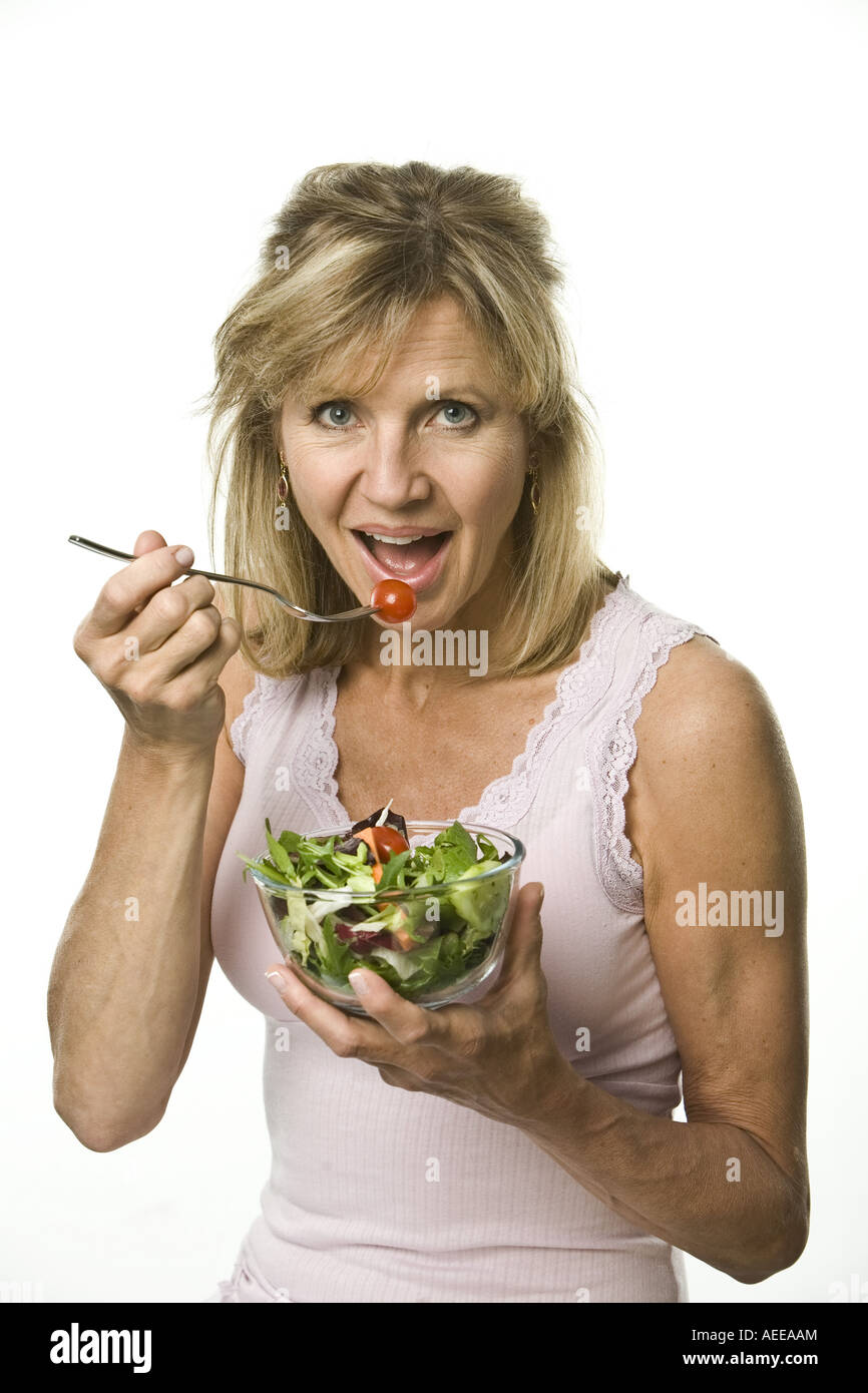A slender woman in her forties eating a salad Stock Photo - Alamy