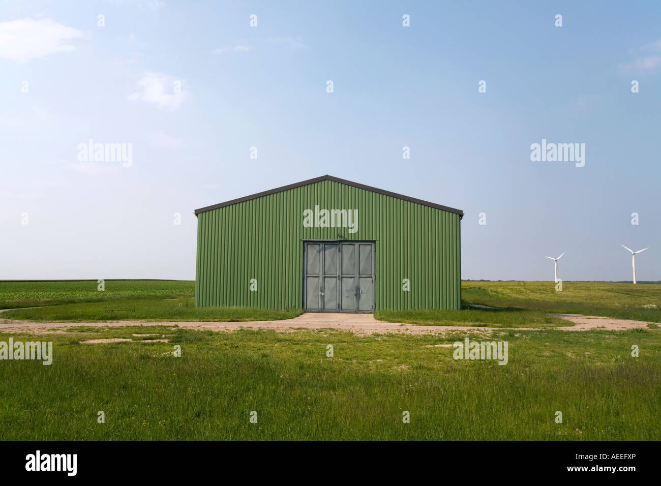 A green metal building and two windmills Stock Photo - Alamy