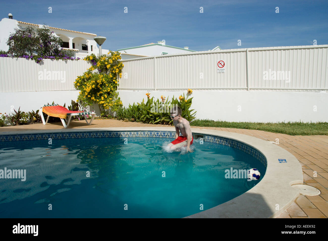 9 year old boy jumping into a swimming pool on holiday Stock Photo - Alamy