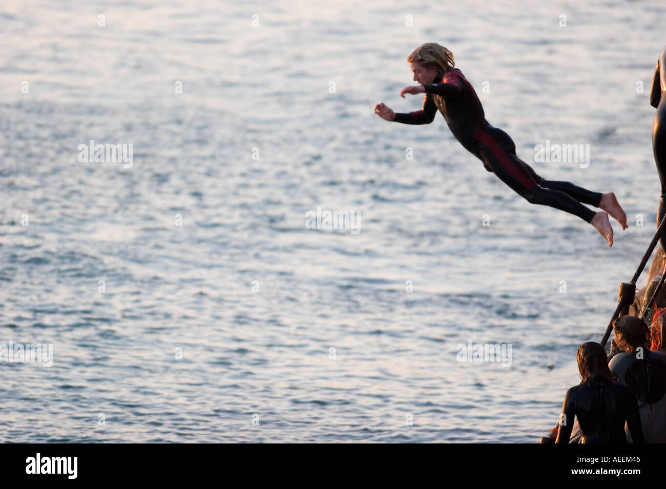 Young boy jumping off sea steps St Ouens Jersey Channel Islands Stock ...