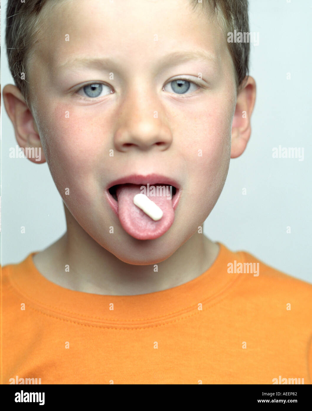 boy opening his mouth to display tablet on his tongue Stock Photo - Alamy