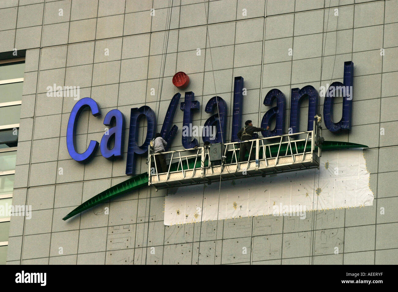 Shanghai China Construction workers putting up illuminated lettering ...