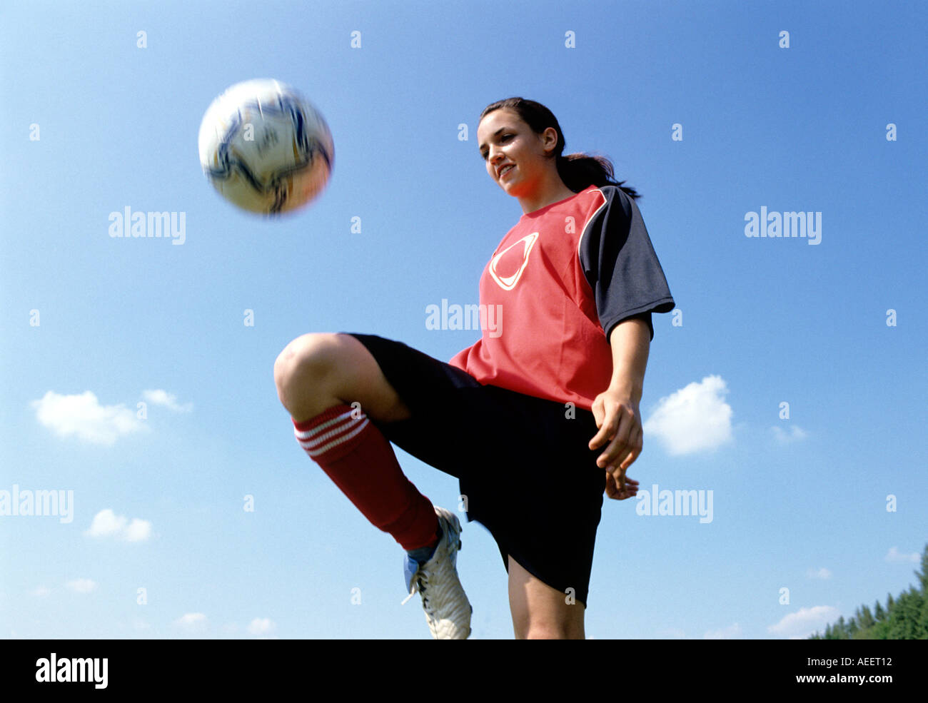 young girl bouncing the ball on her knee Stock Photo - Alamy