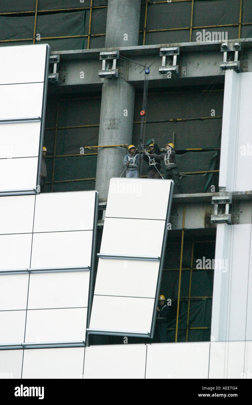 Shanghai China Construction workers positioning cladding panels on a ...