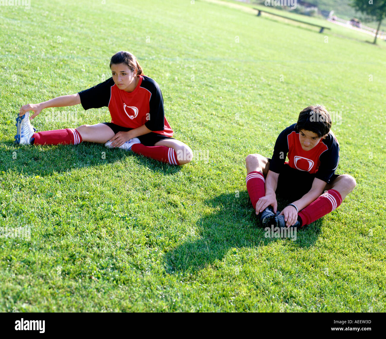 two teenagers in football gear doing stretching exercises Stock Photo ...