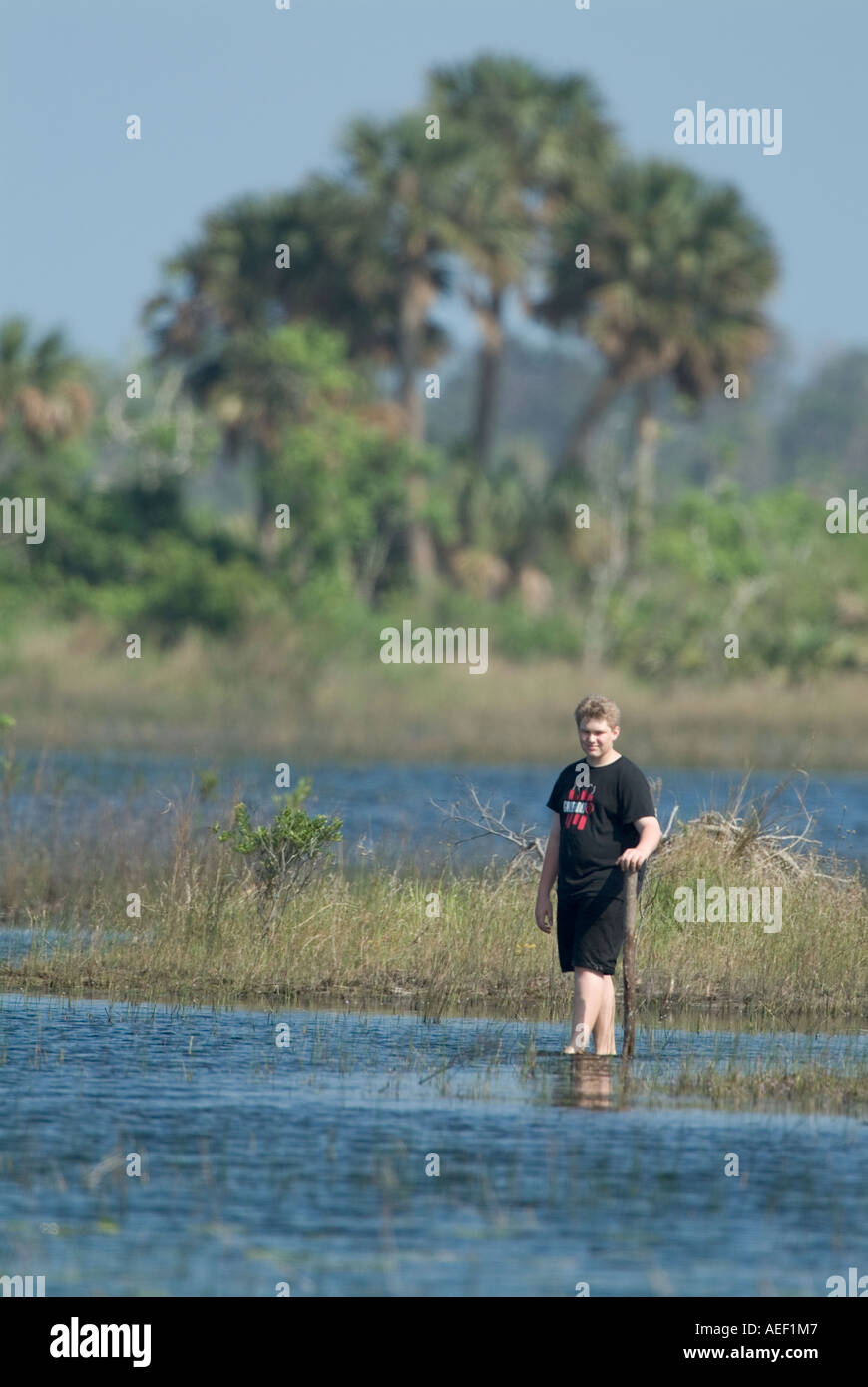 boy on adventure in wetland exploring wading through wetlands child ...