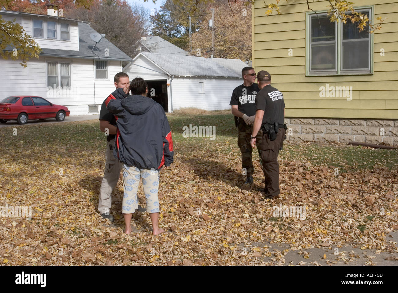 Deputy sheriff talking to resident during the execution of a narcotics ...