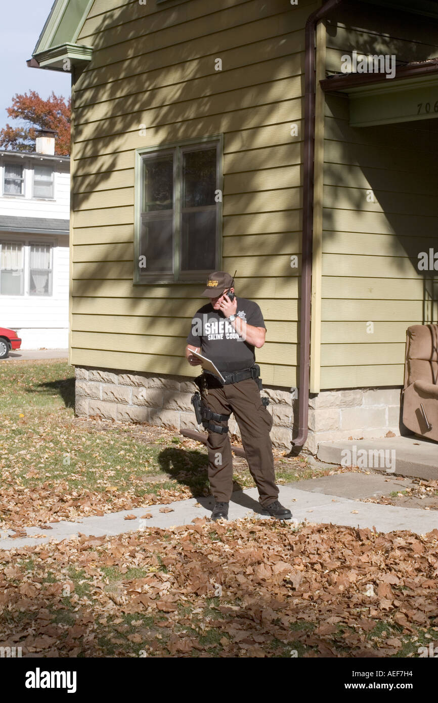 Deputy sheriff using handheld radio to contact dispatch during the ...