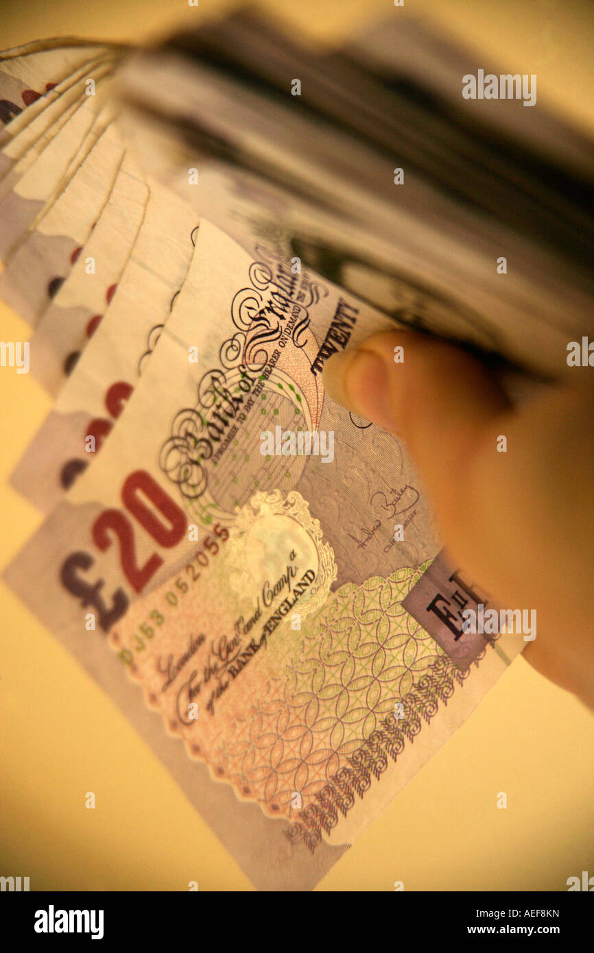 Holding a bunch of twenty pound notes Stock Photo - Alamy