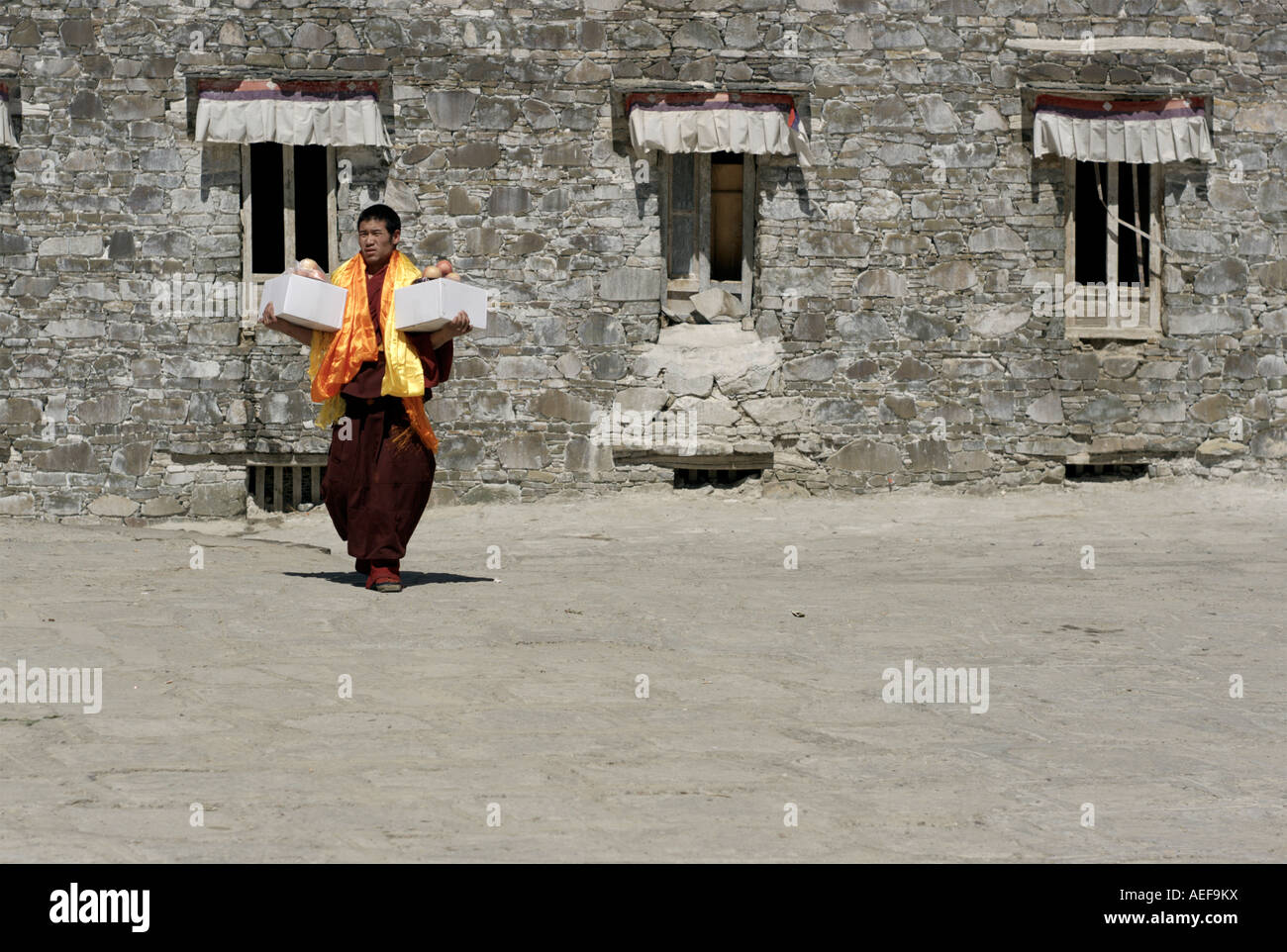 Monk carrying boxes of fruit Stock Photo - Alamy