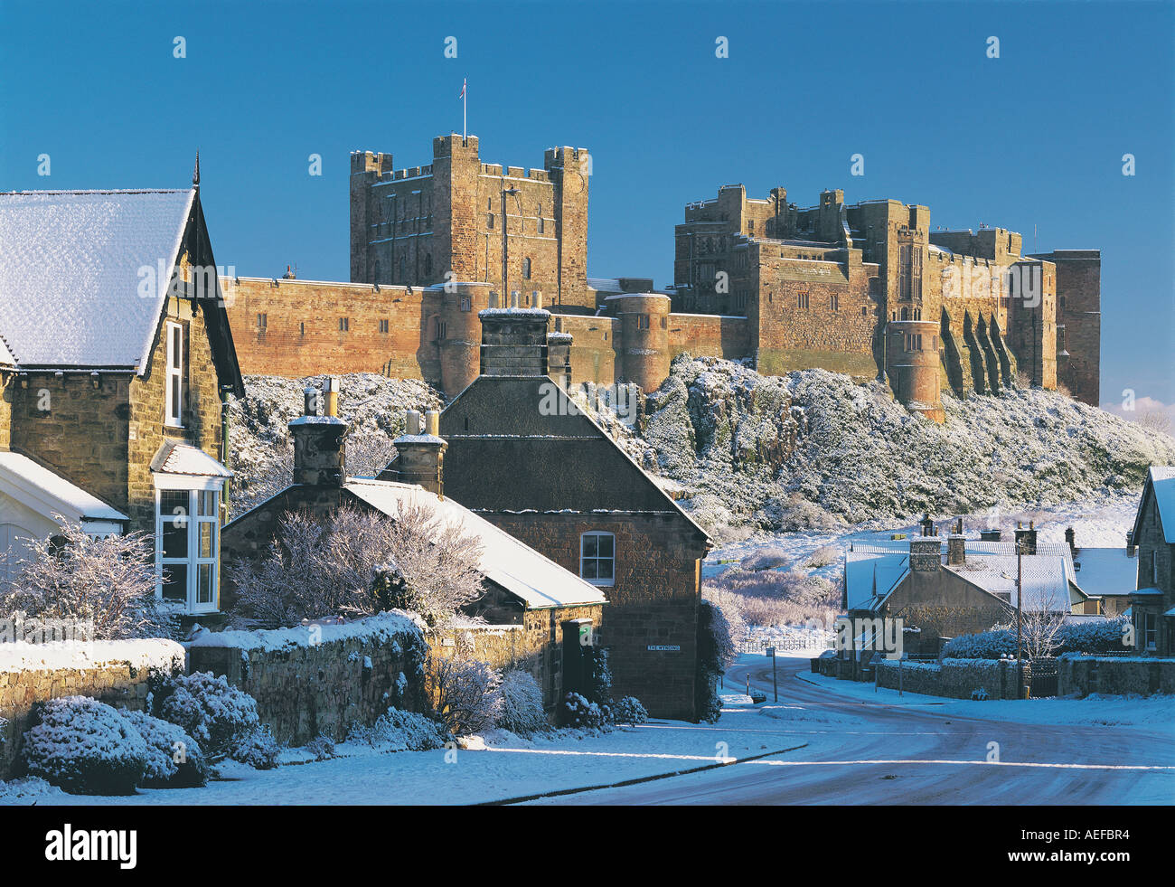 Bamburgh Castle and village in the snow Northumberland UK Stock Photo ...