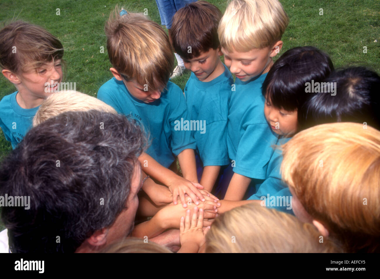 kids and coach in junior soccer league clasp hands before game. Redondo ...
