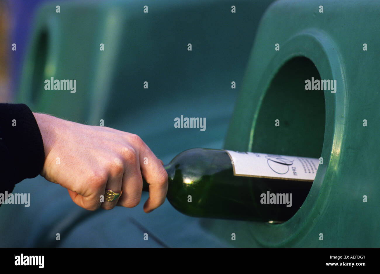 person throwing glass bottle into bottle bank recycling bin Stock Photo ...