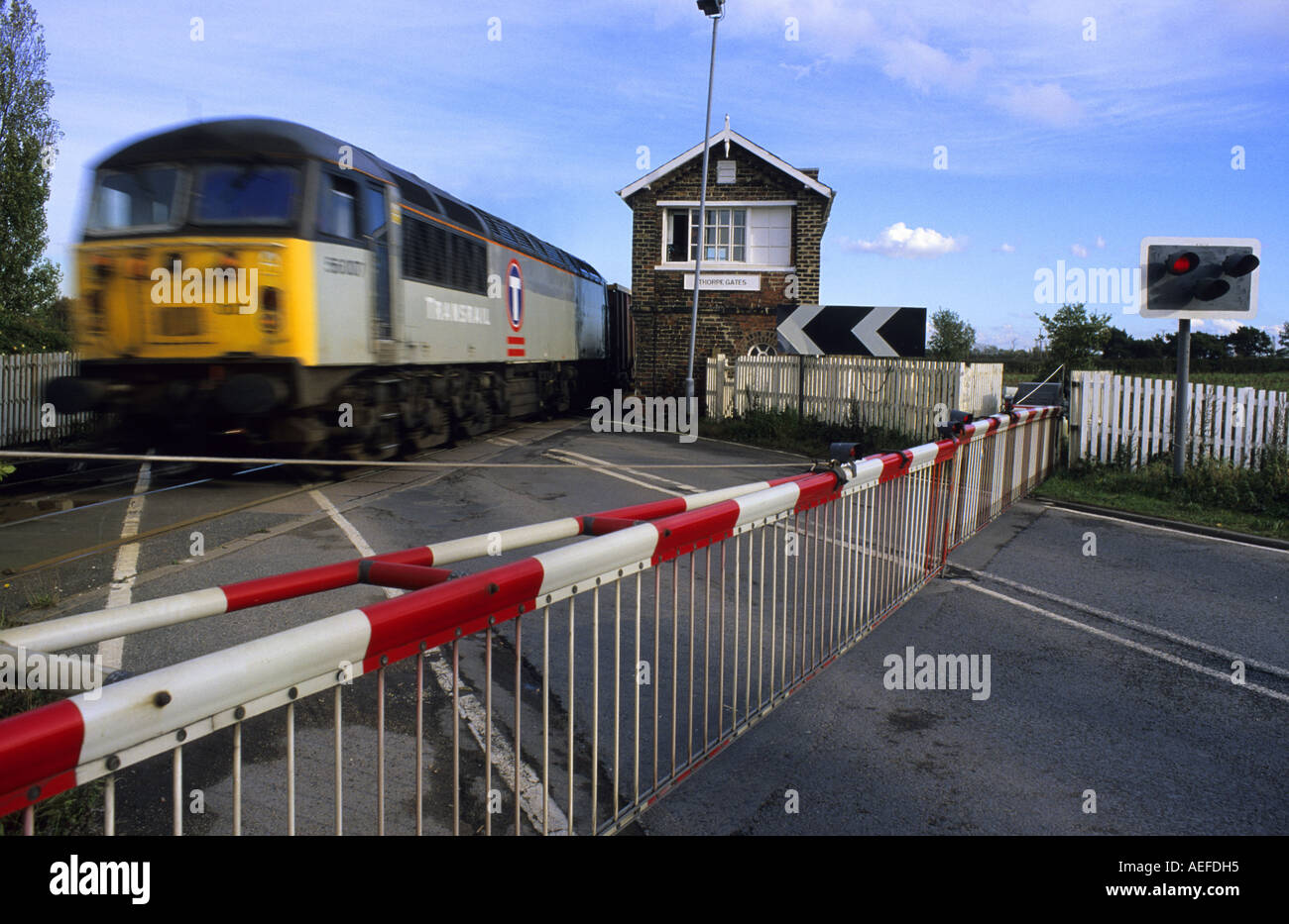 train passing level crossing and signal box at thorpe willoughby ...