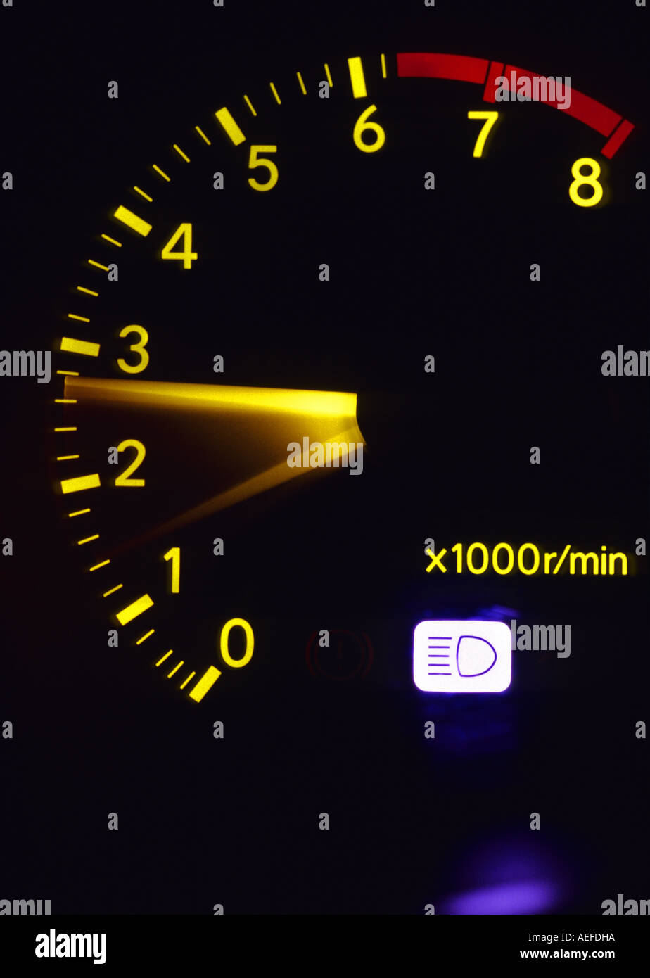 engine revolution counter dial on dashboard console of vehicle at night ...
