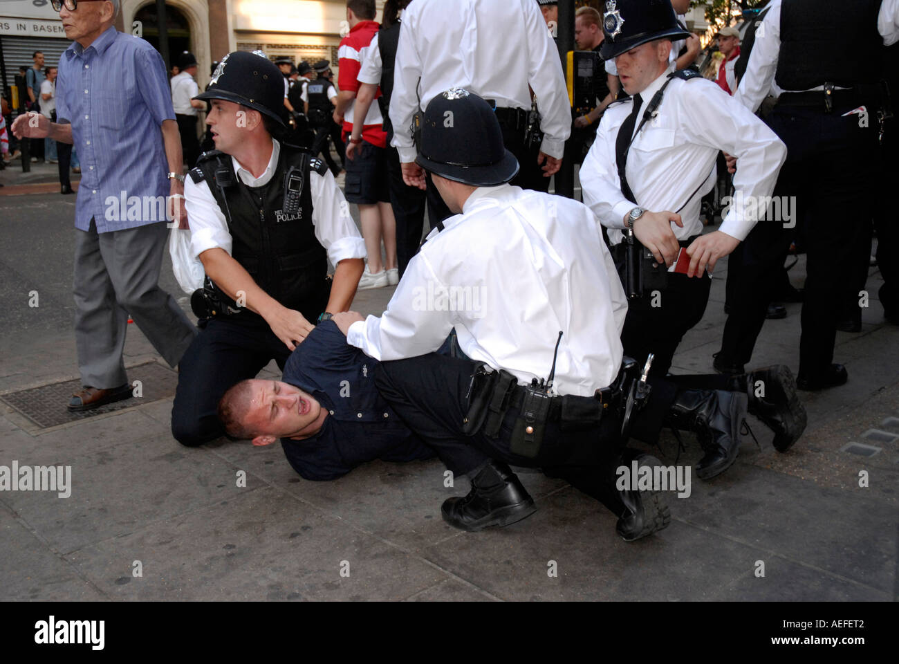 Police officers hold handcuff and arresting young football fan Central ...