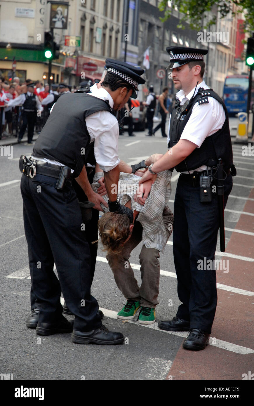 Police officers hold handcuff and arresting young football fan Central ...
