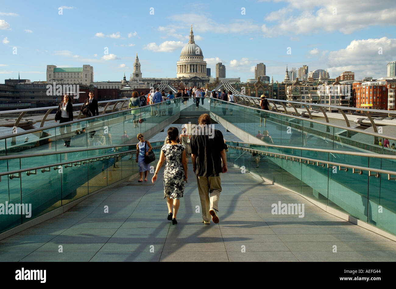 People crossing the Millennium Bridge from the Southbank with St Paul's Cathedral and London ...