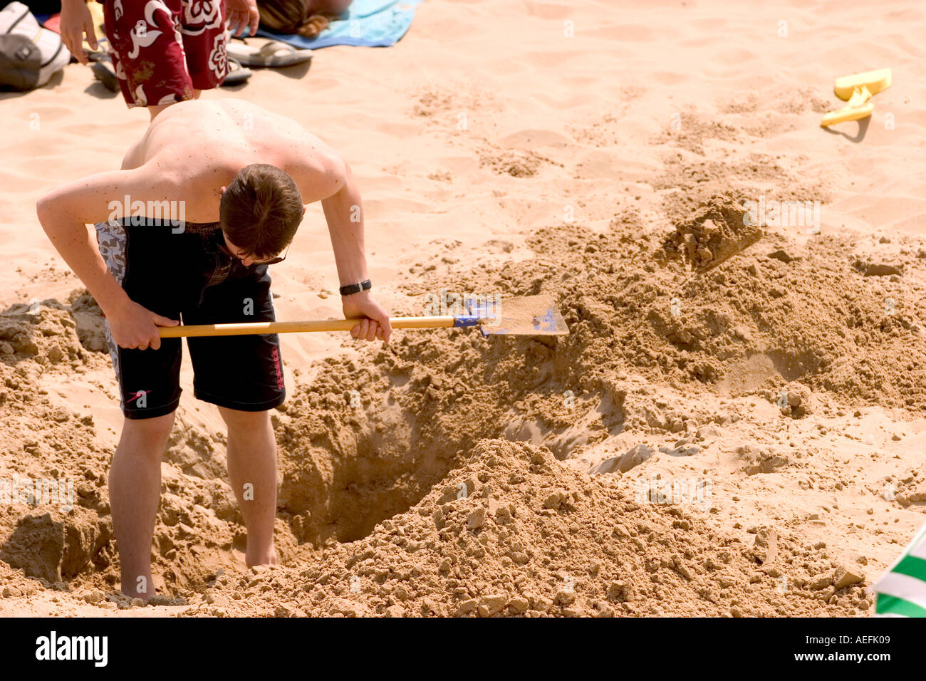 alone teen digging in beach sand Stock Photo - Alamy