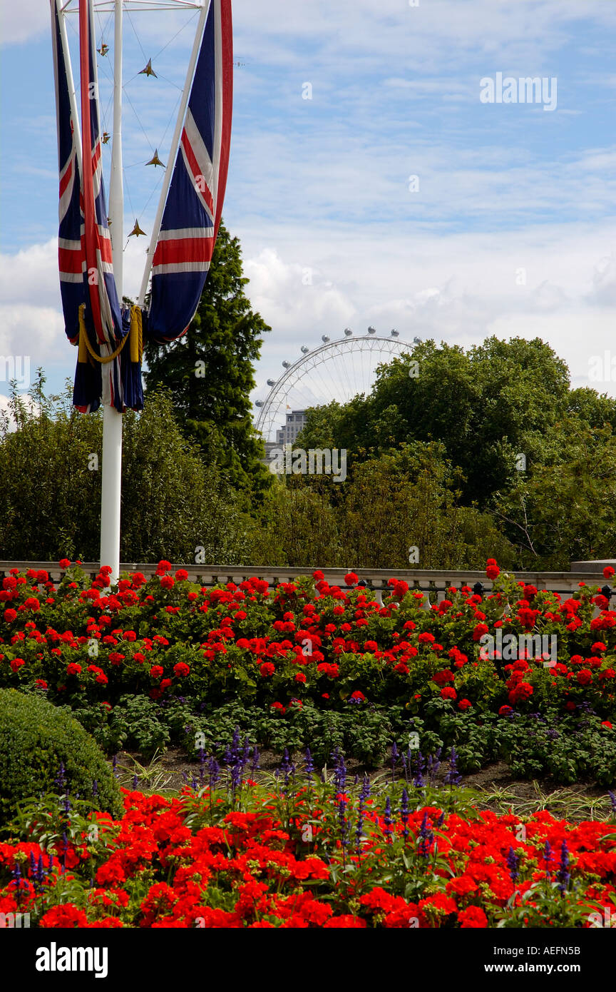 London Eye with Union Jack flag and flowers in foreground Stock Photo ...