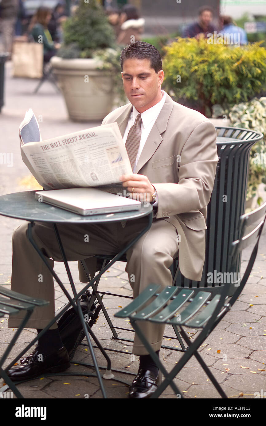 Business man reading a paper in the park Stock Photo - Alamy