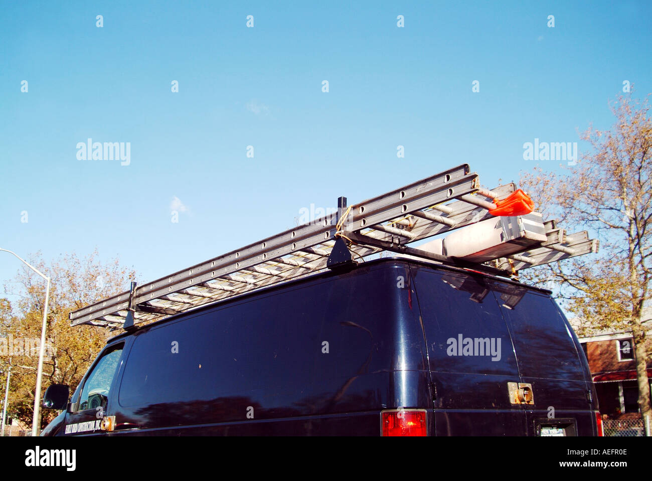 Utility van with ladder on top Stock Photo - Alamy