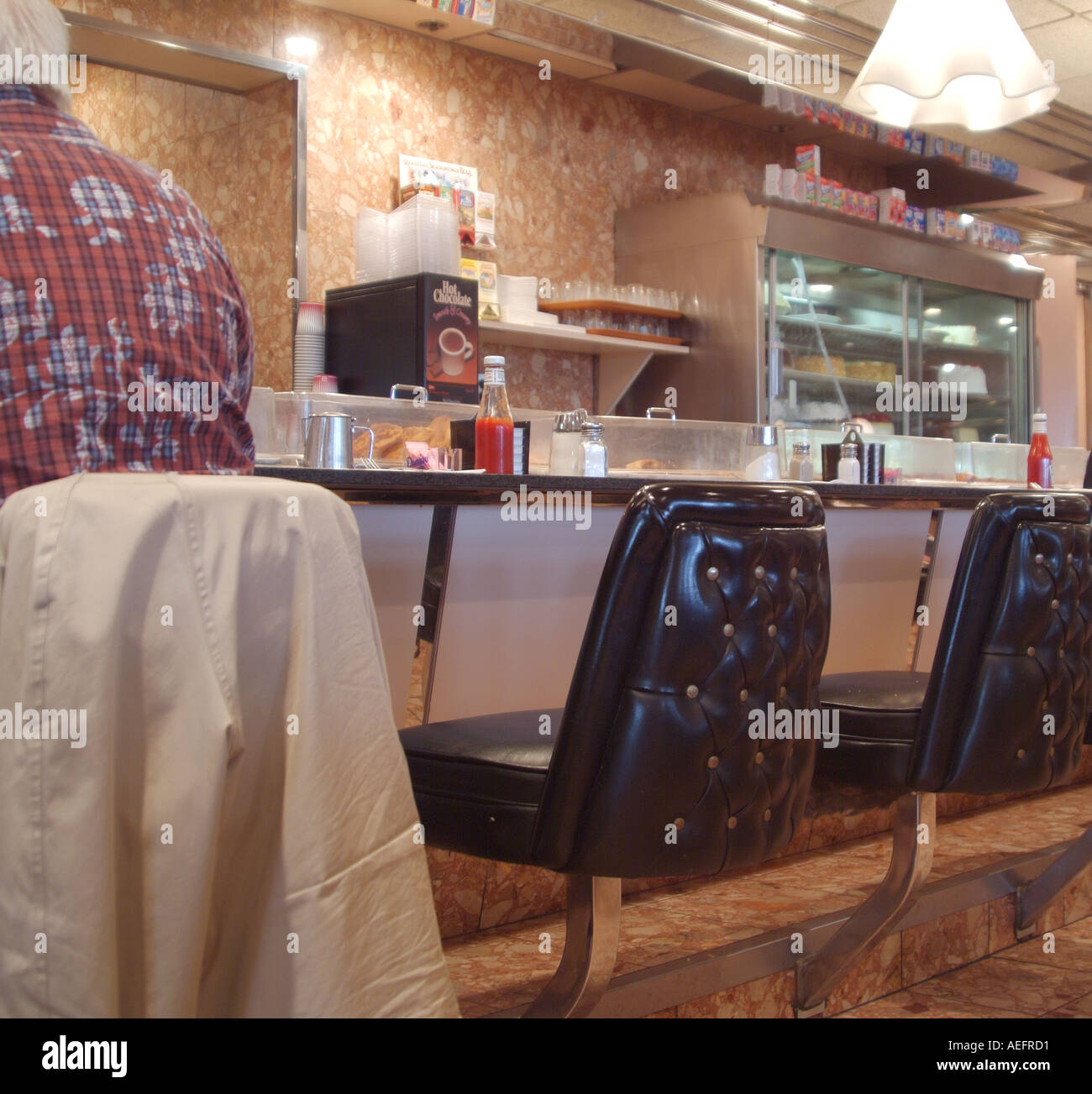 Old man sitting a diner counter Stock Photo - Alamy