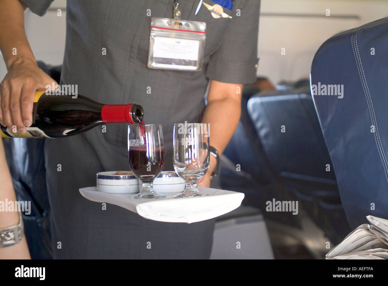 Flight attendant pouring drinks Stock Photo - Alamy