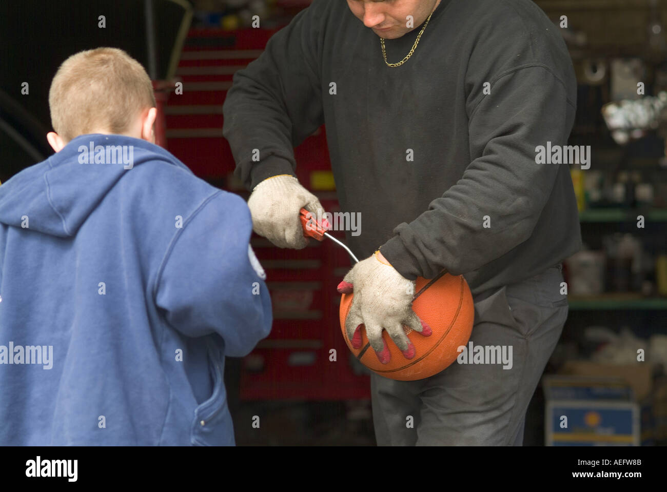 Mechanic putting air in ball Stock Photo - Alamy