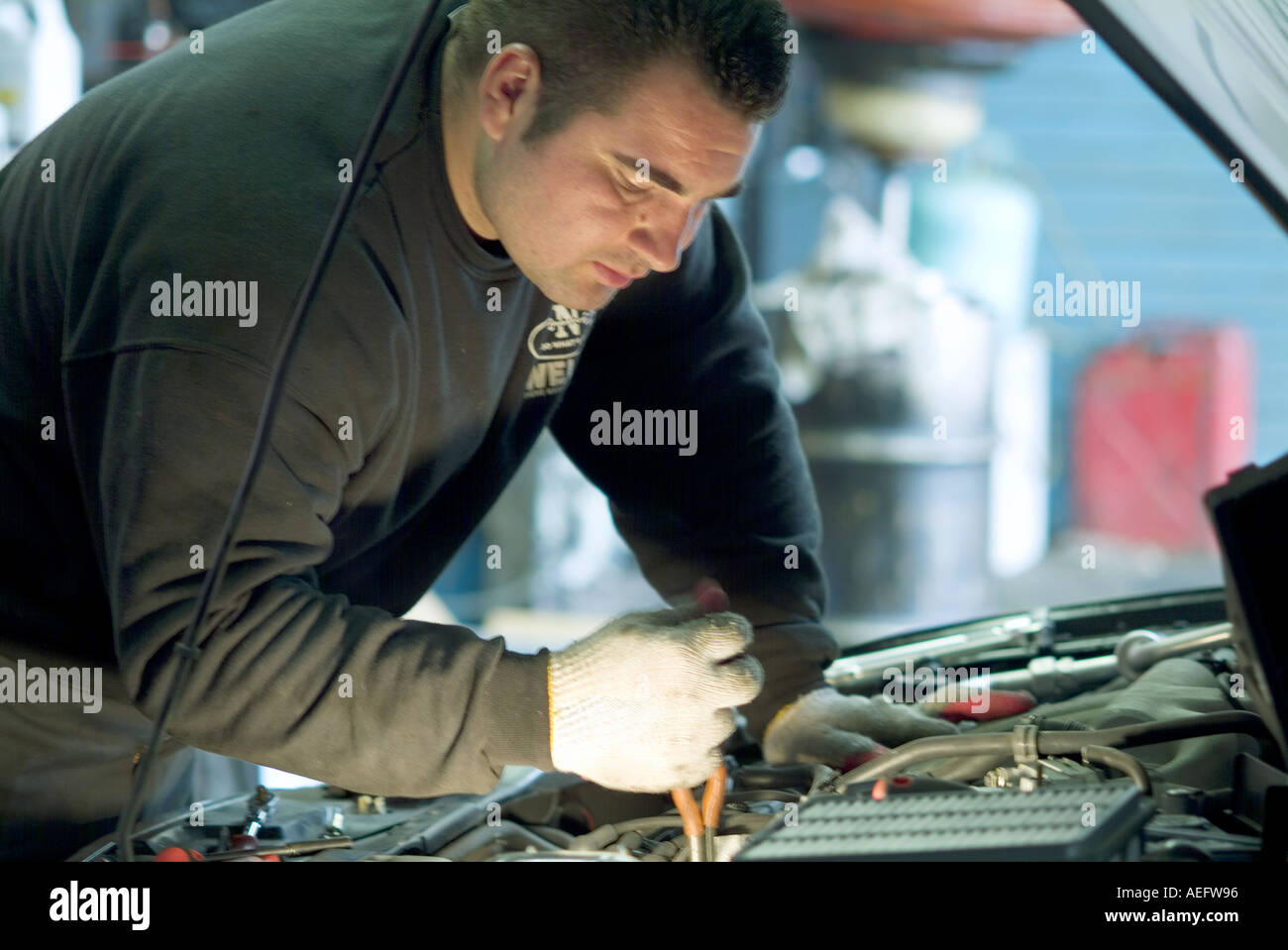Mechanic working on engine Stock Photo - Alamy