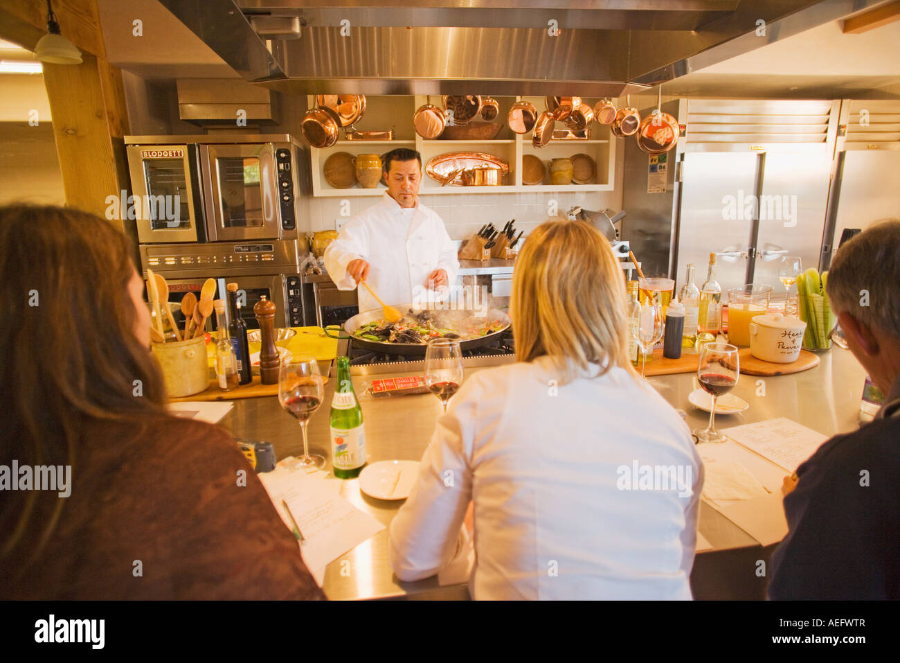 a chef prepares a traditional Spanish dish of paella at a cooking class ...