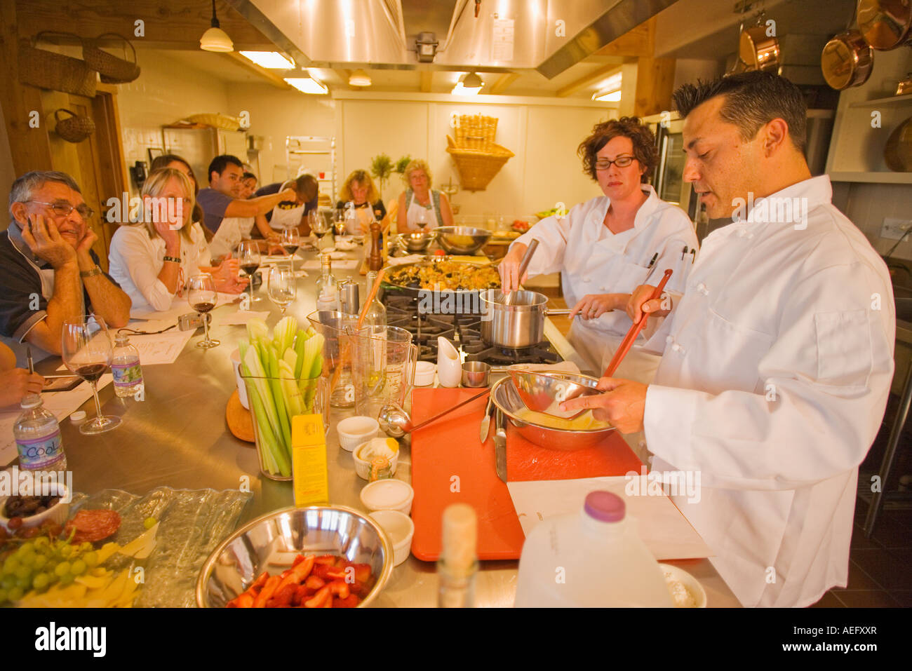 a chef prepares a traditional Spanish dish of paella at a cooking class ...