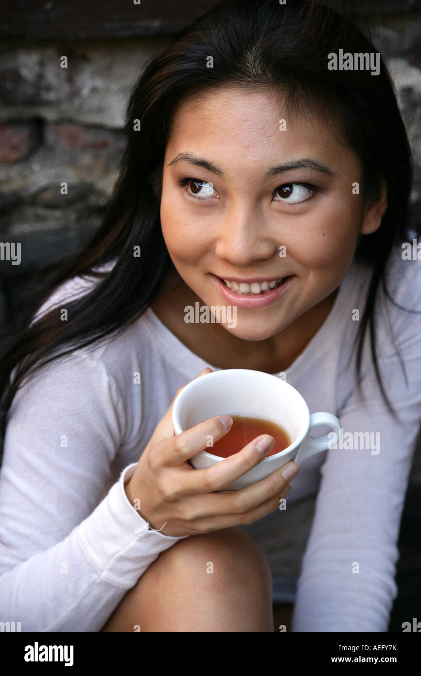 Young woman enjoying tea Stock Photo - Alamy