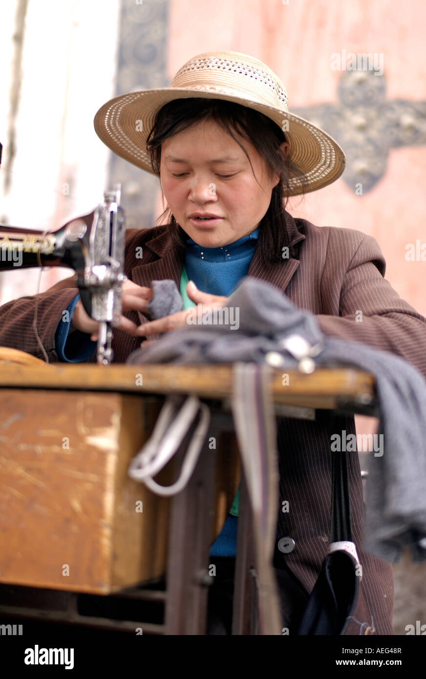 Woman sewing clothes in Lhasa street Stock Photo - Alamy