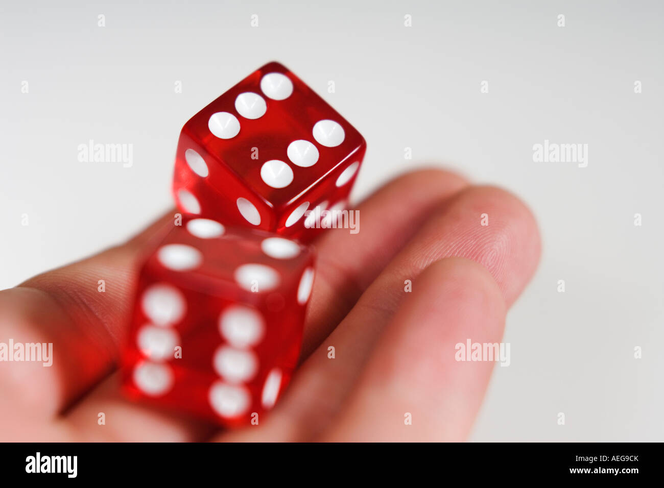 Two cherry red dice being thrown from the left hand showing double six ...