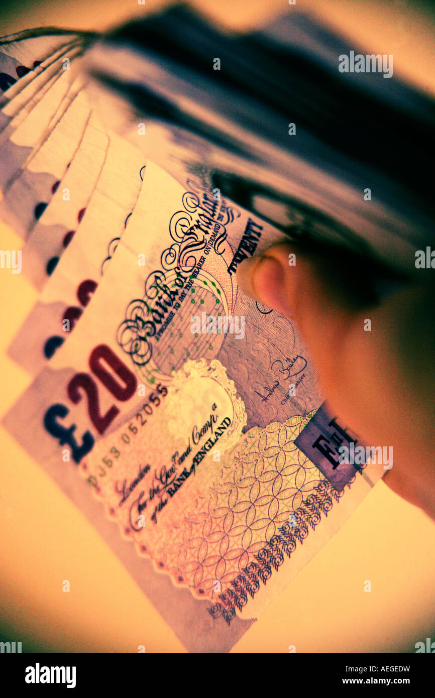 Holding a bunch of twenty pound notes Stock Photo - Alamy