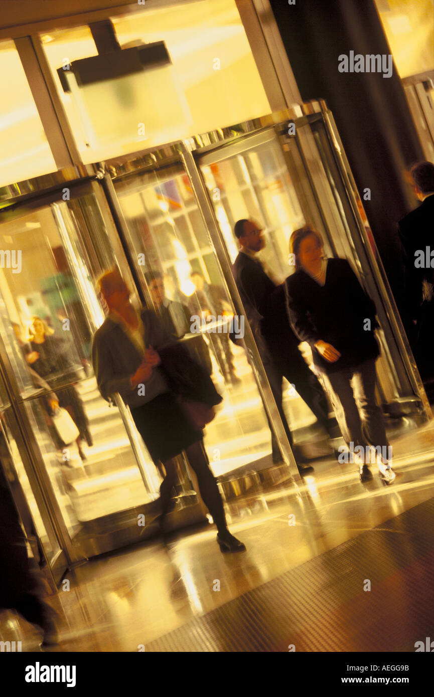 Business people walking through revolving glass doors Stock Photo - Alamy
