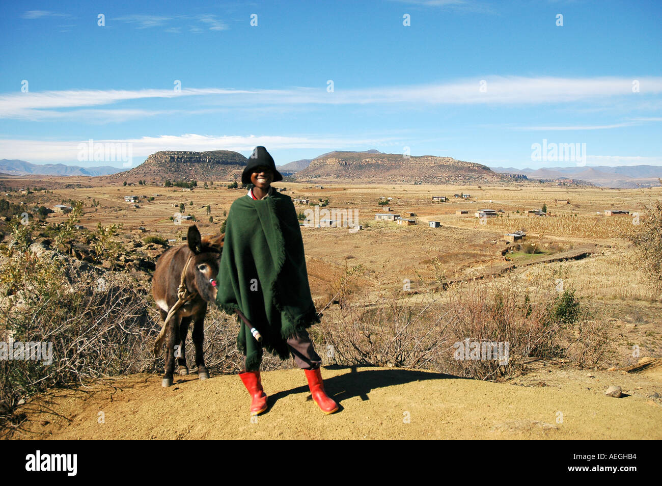 Herder boy in green cape and hat in the dry mountains of Lesotho Stock ...