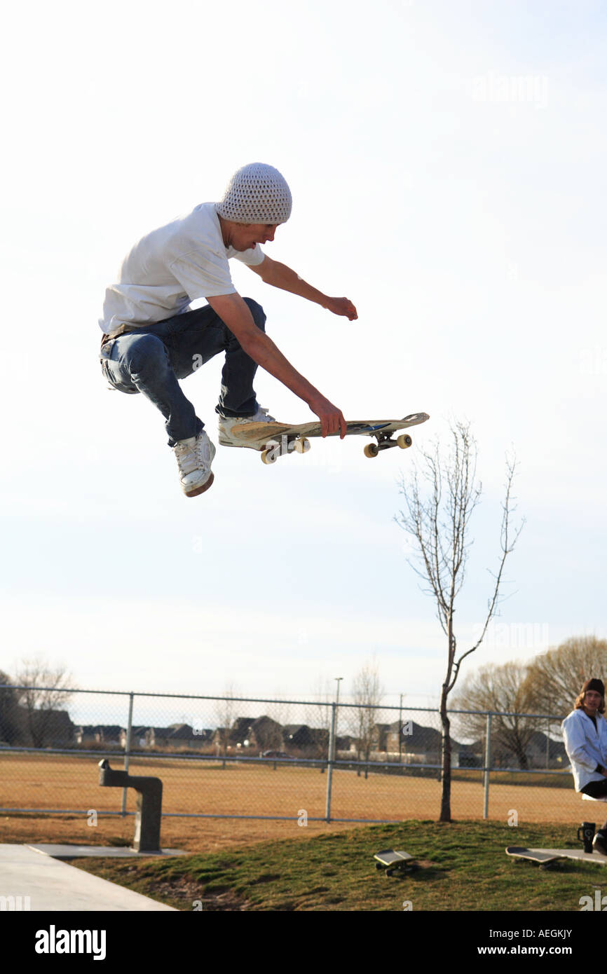 Teenage boy flying high out of concrete skate park bowl Stock Photo - Alamy