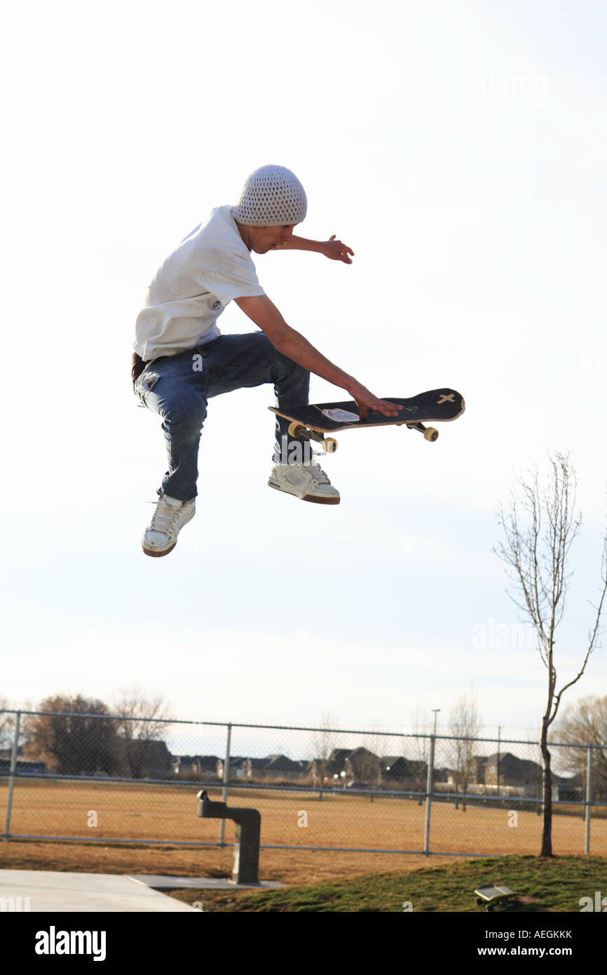 Teenage boy flying high out of concrete skate park bowl Stock Photo - Alamy