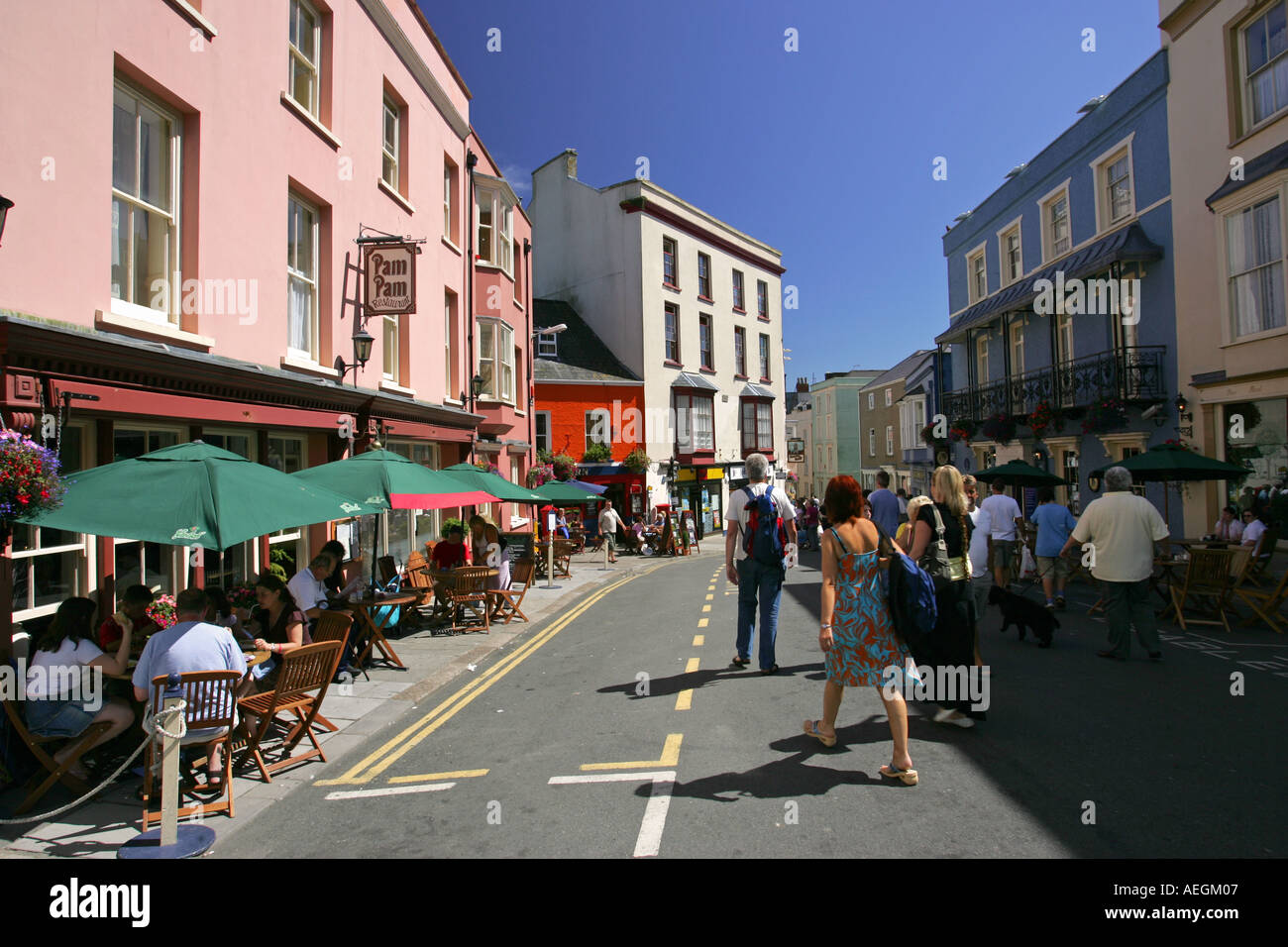 Tourists explore the colourful town centre of popular coastal holiday ...