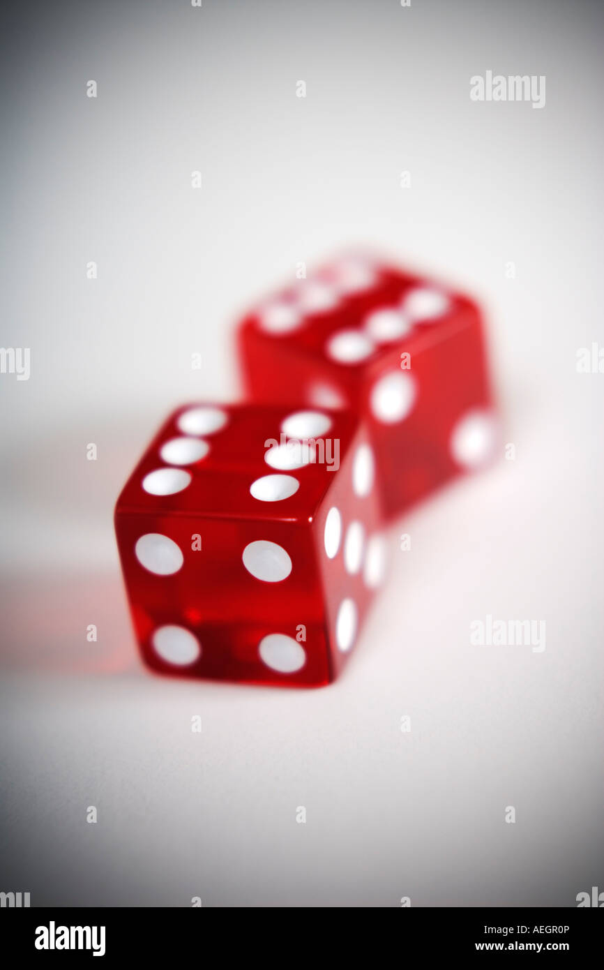 Two cherry red dice showing double six' on a white surface and ...