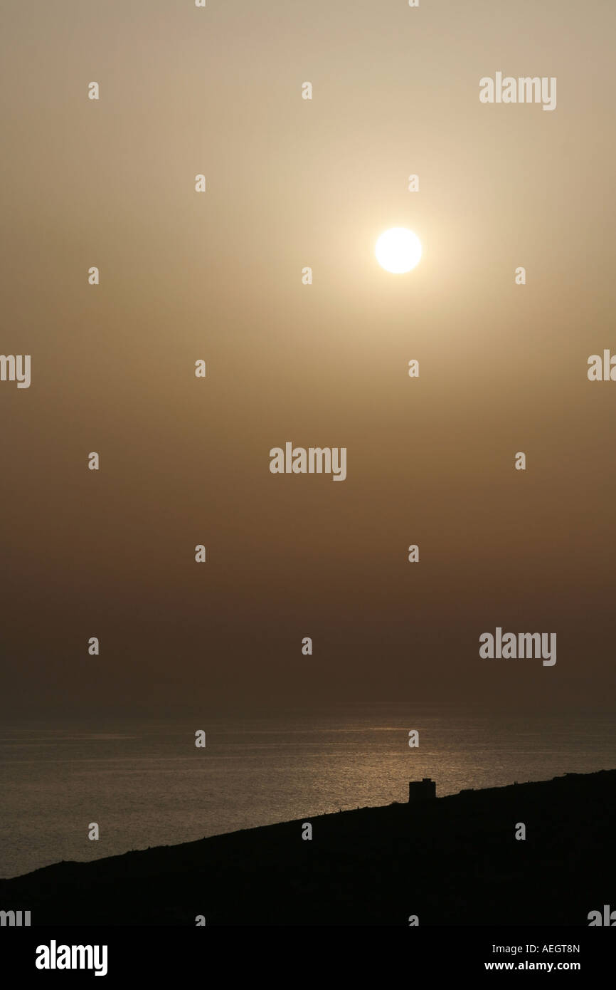 Coastal watchtower in Malta beneath a sinking sun Stock Photo - Alamy