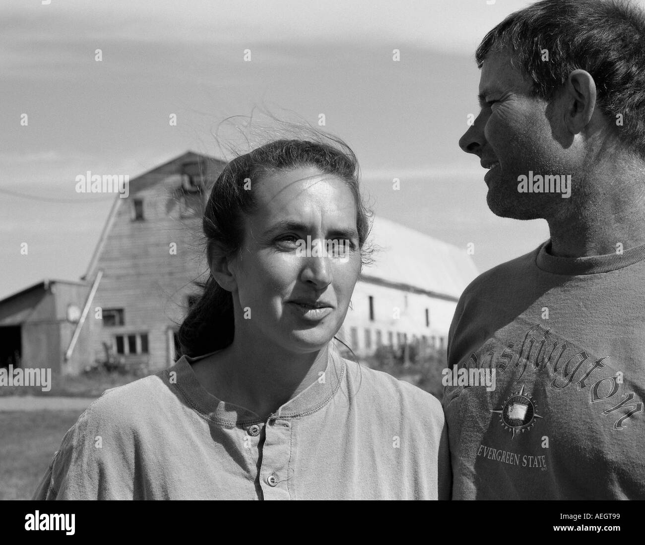Farm couple standing in front of barn Stock Photo - Alamy