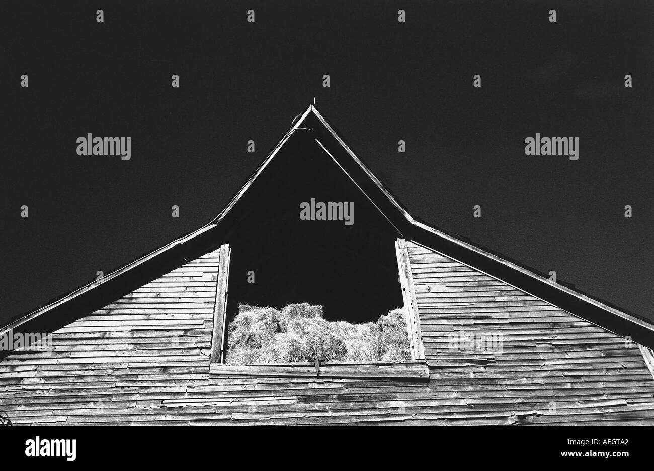 Bales of hay showing throughout barn window Stock Photo - Alamy