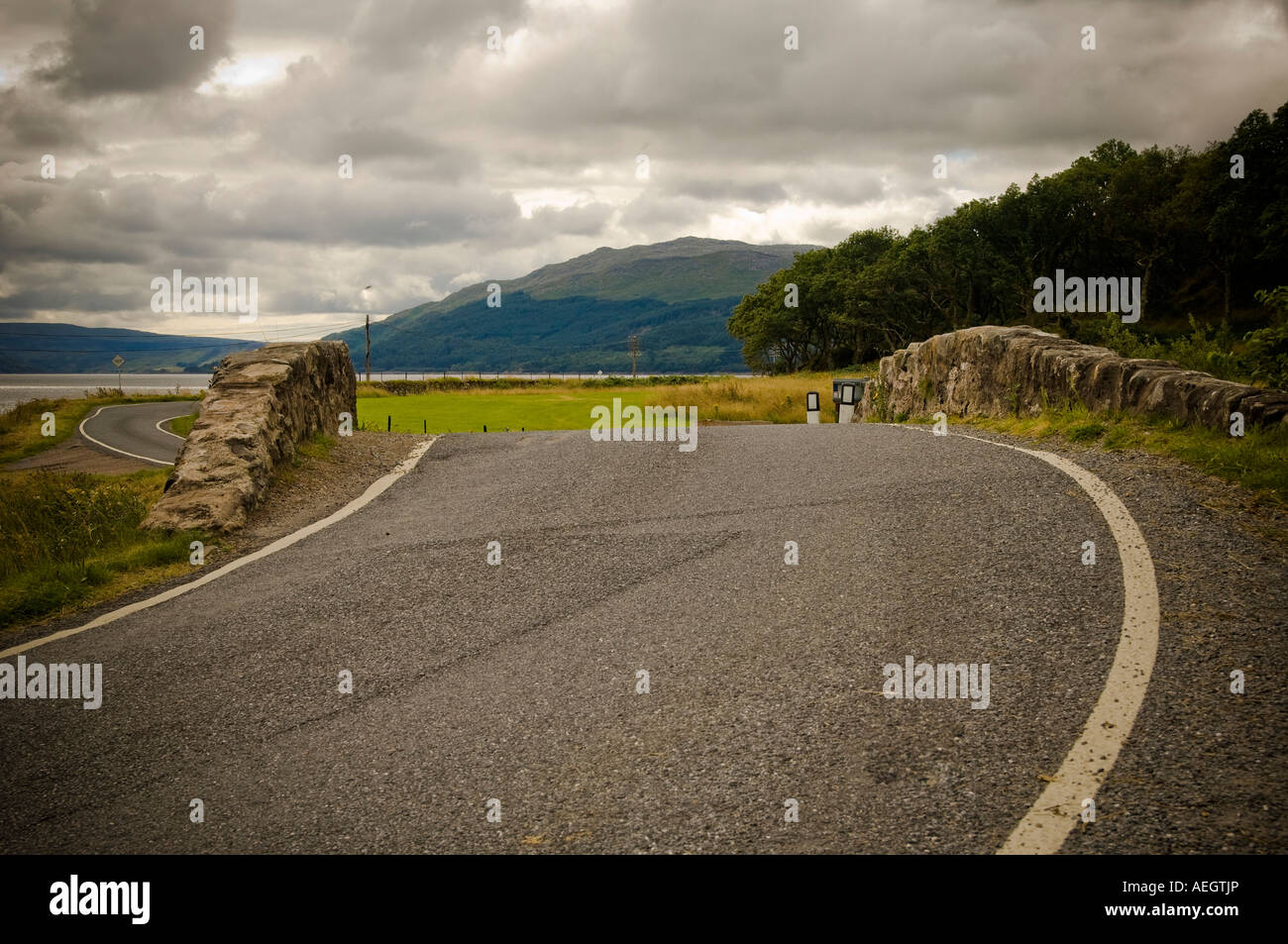 Landscape with road and hump backed bridge Stock Photo - Alamy