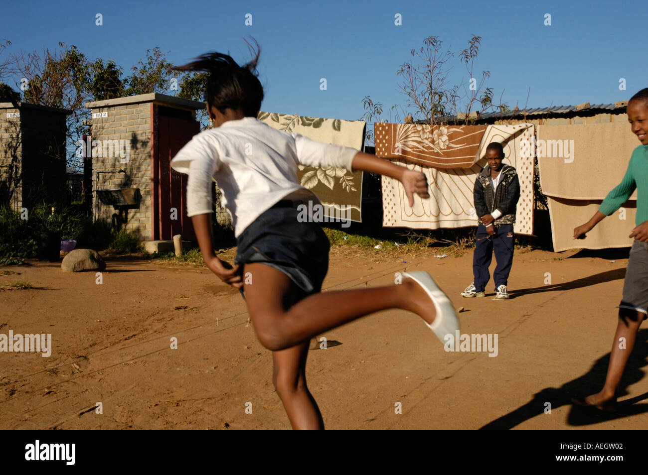 Young black girls children skipping in front of their township home in ...