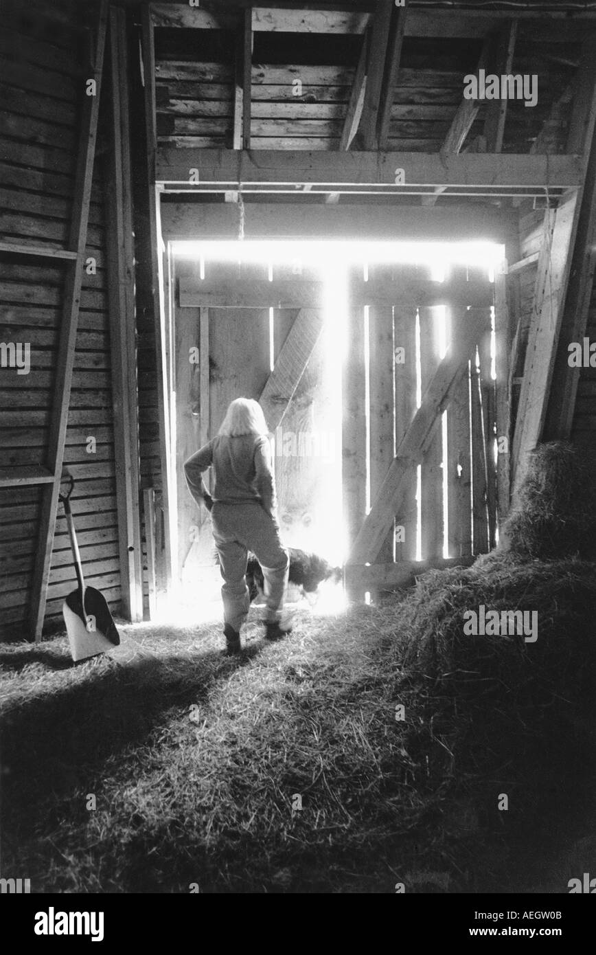Older farm woman exiting barn Stock Photo - Alamy
